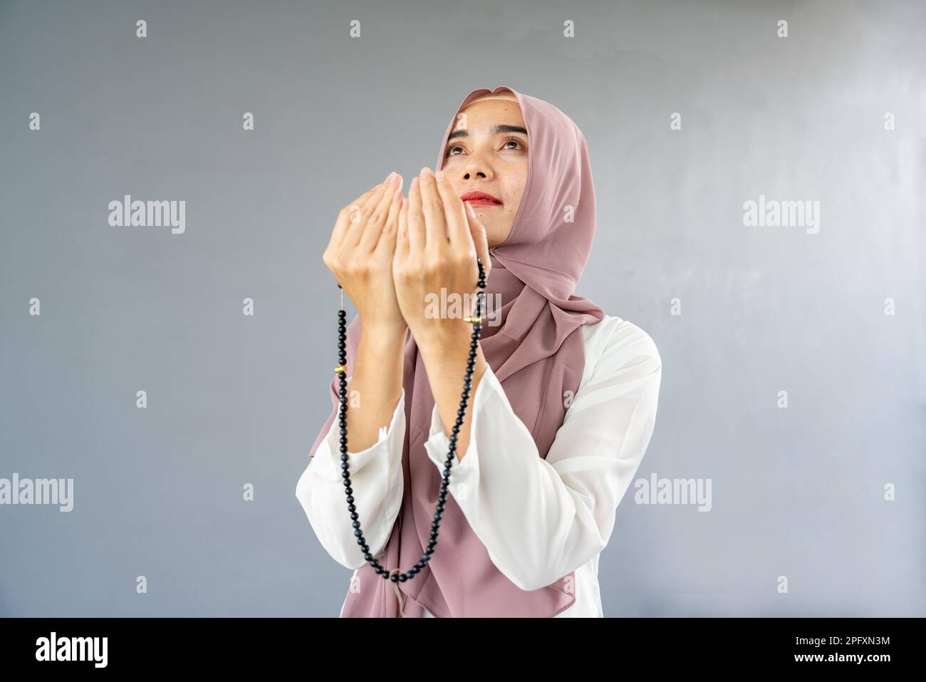 Muslim woman reading a book on gray background, in Islam study. Hand of ...