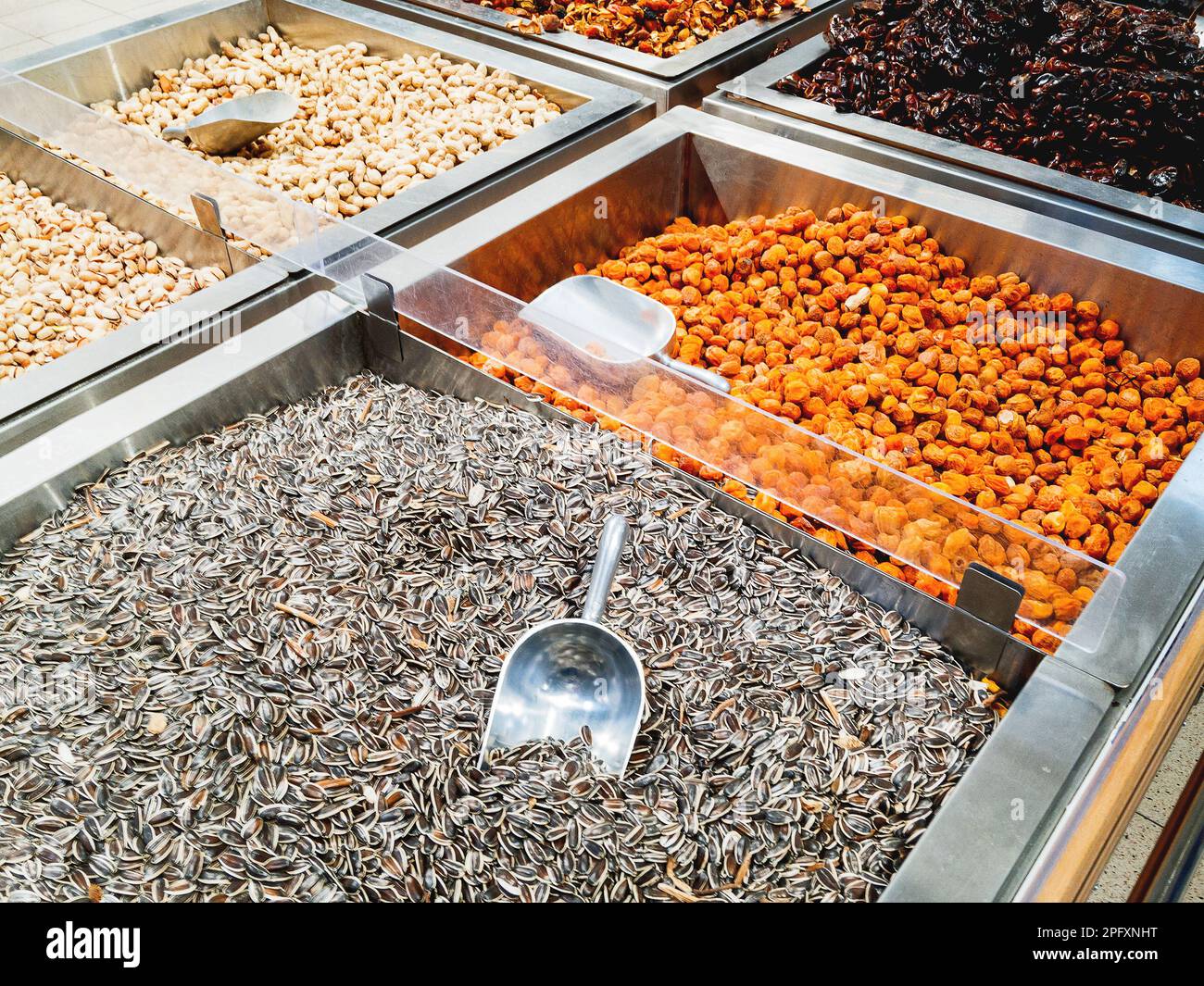 Boxes with sunflower seeds, dried fruits and nuts. A special scoop for ...