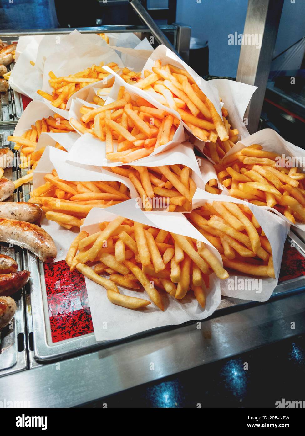 Portions of french fries in white packages lie in the shop window ...