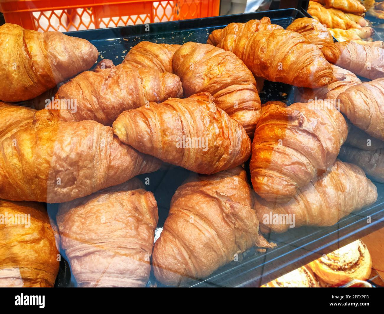 Fresh croissants lie in the shop window. Baked rolls in storefront ...