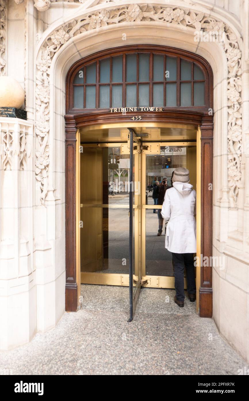 Patron entering Tribune Tower, Chicago, through revolving gold doors ...