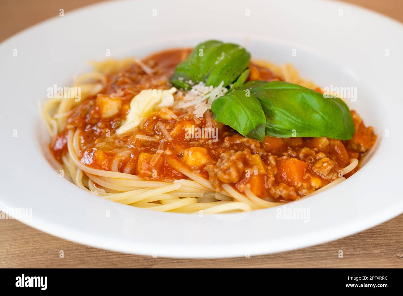 homemade spaghetti bolognese with minced meat with juicy green basil ...