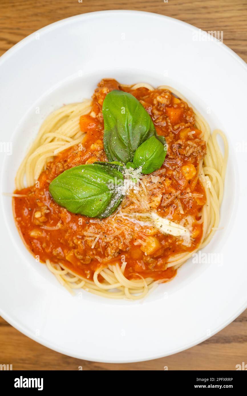 homemade spaghetti bolognese with minced meat with juicy green basil ...