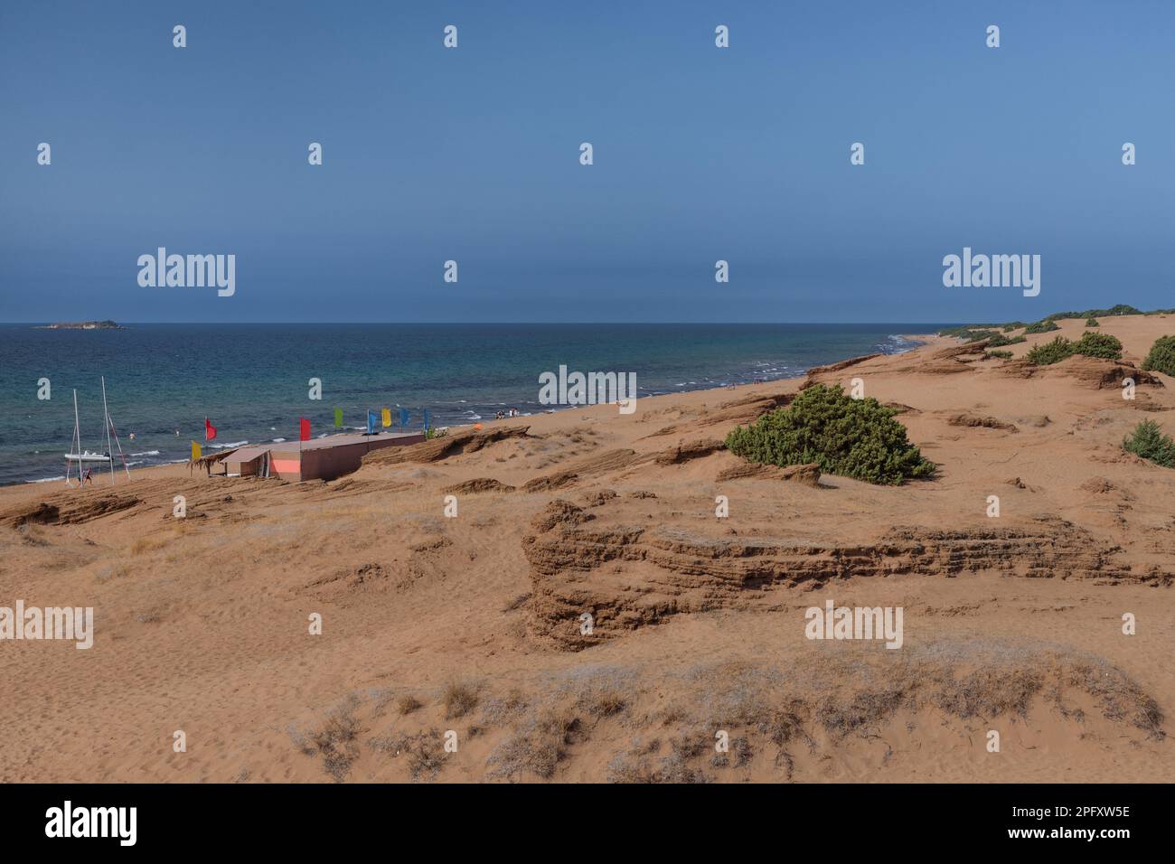 Corfu Island beach, dark yellow sand. A stretch of beach with a blue ...
