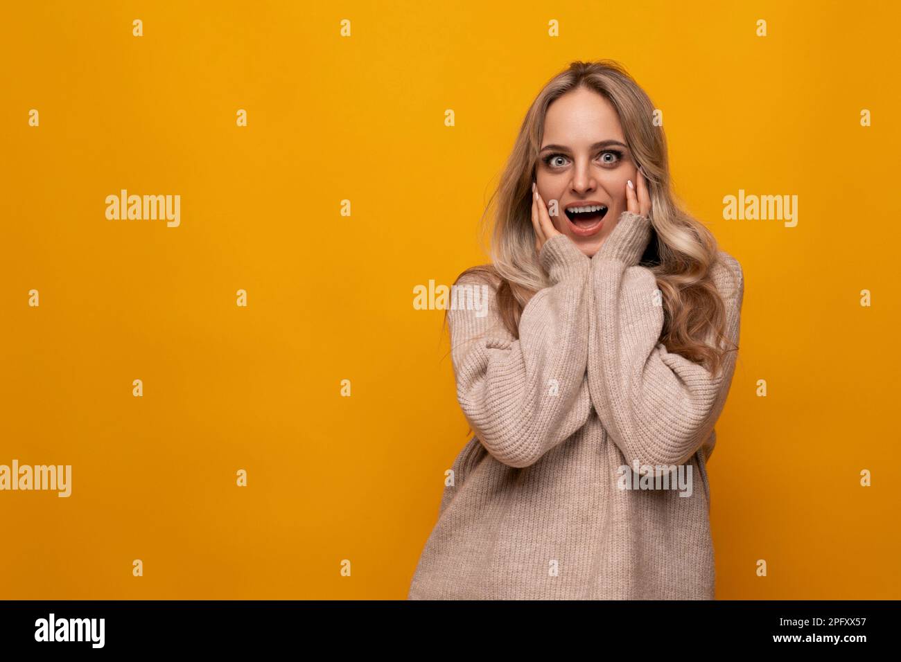 pleasantly surprised young woman over isolated yellow background Stock ...