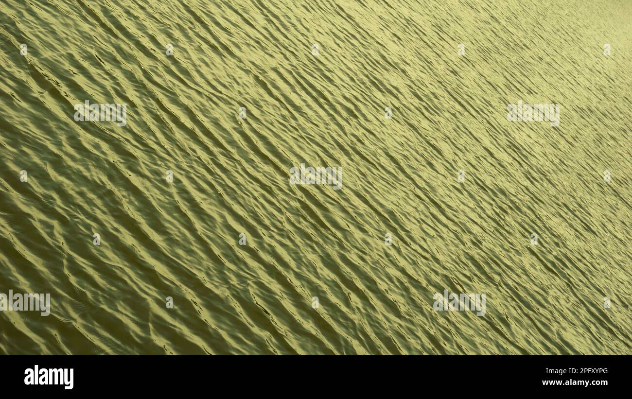 Beautiful natural wave pattern of water with reflection of bright sun ...