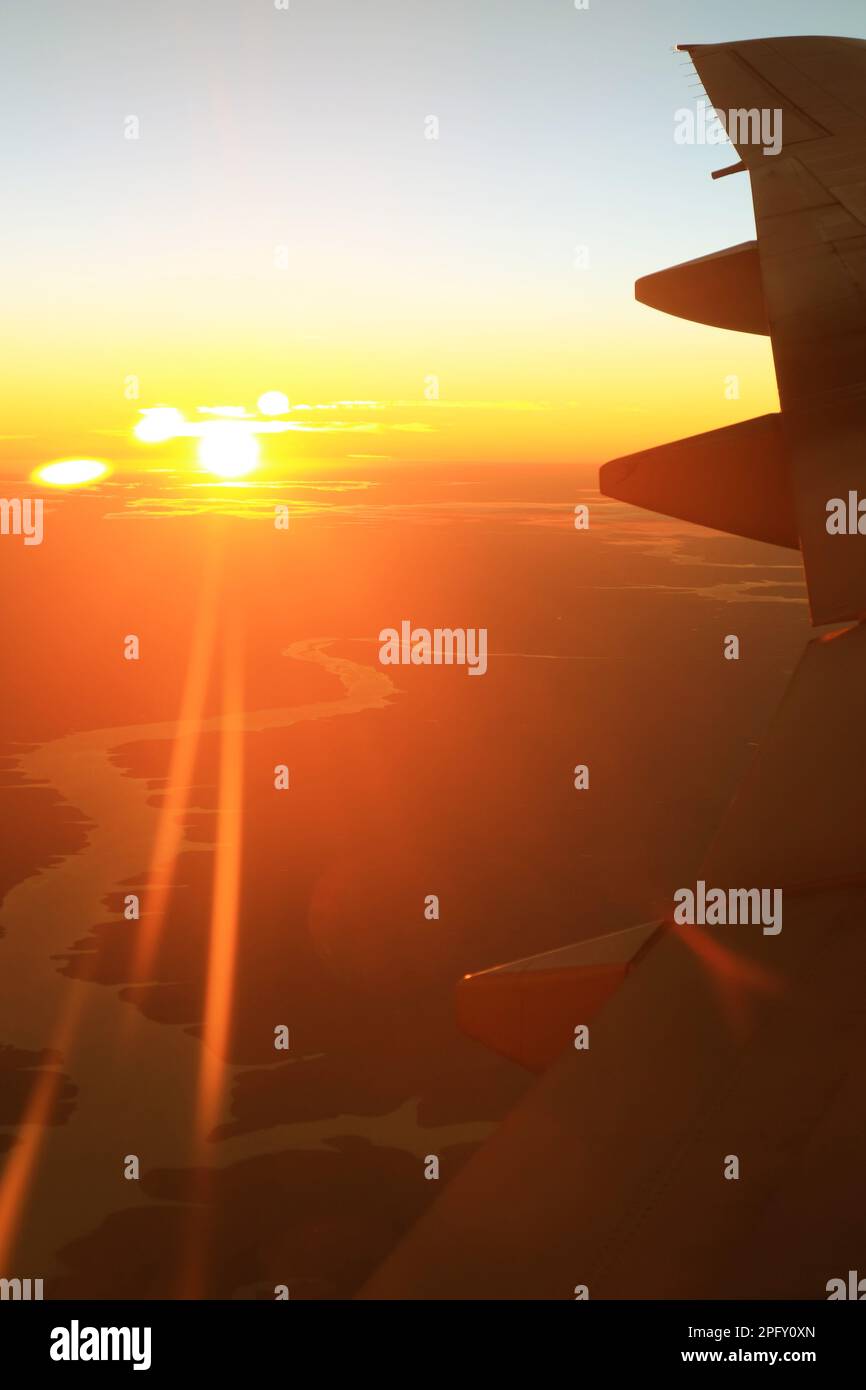 Bright sun rising with stunning sunbeams as seen from the plane window ...