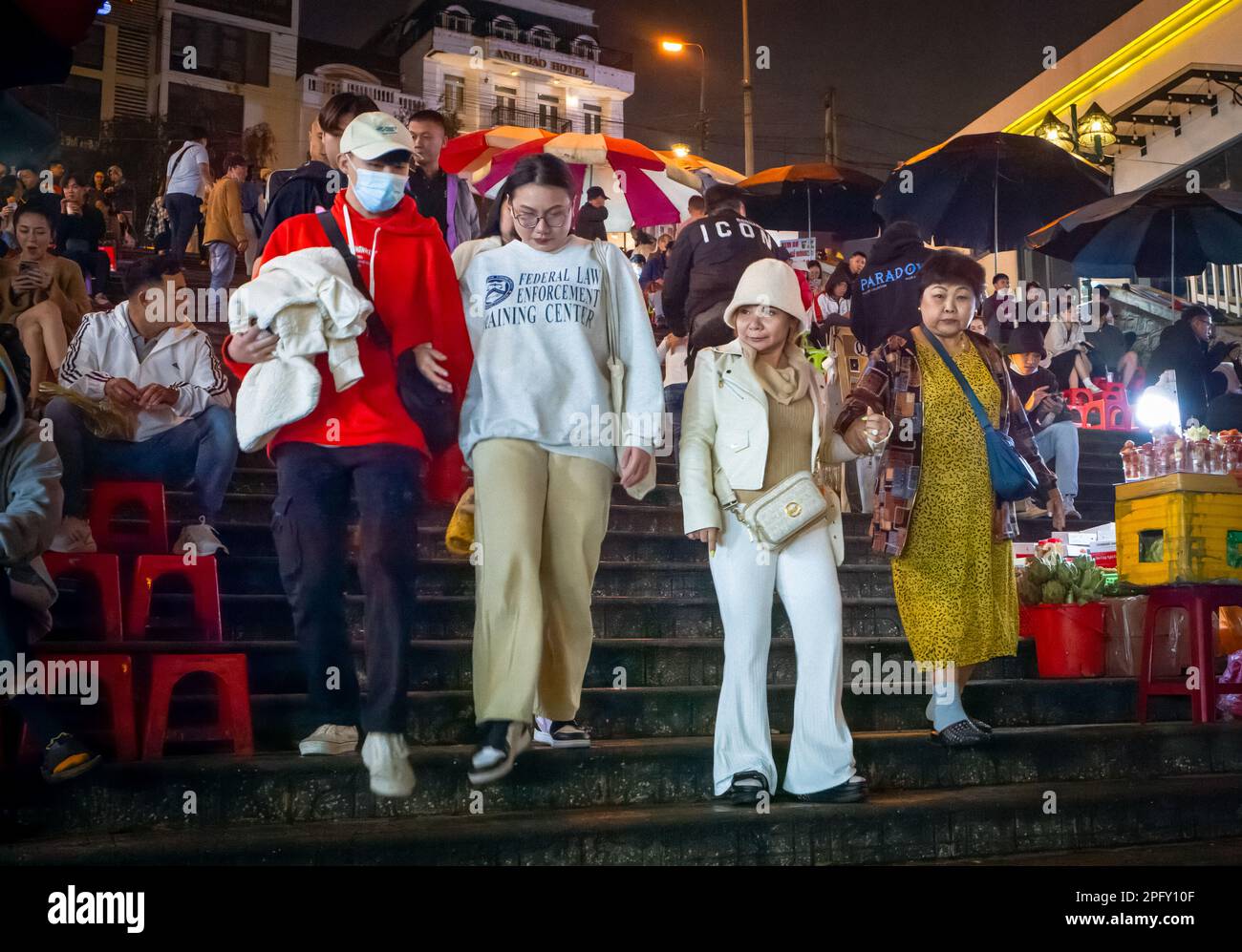 A fashionable elderly Vietnamese woman and her friend walk down steps ...