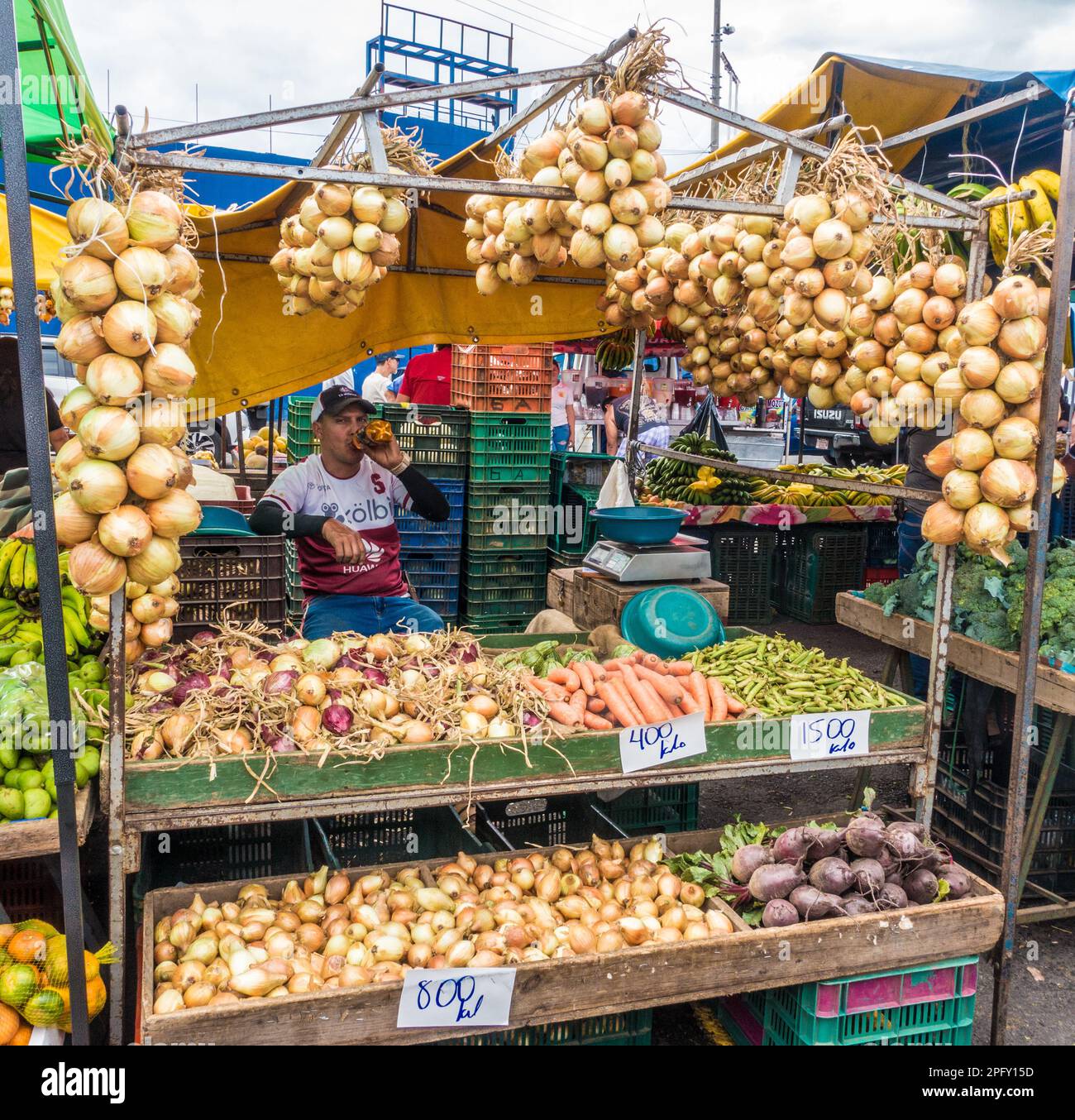 Man drinking soda pop from his vegetable stall at a farmers market in ...