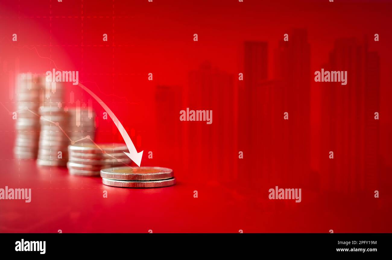 Arrow pointing down over the coin stack as a graph step on red city buildings background with ...