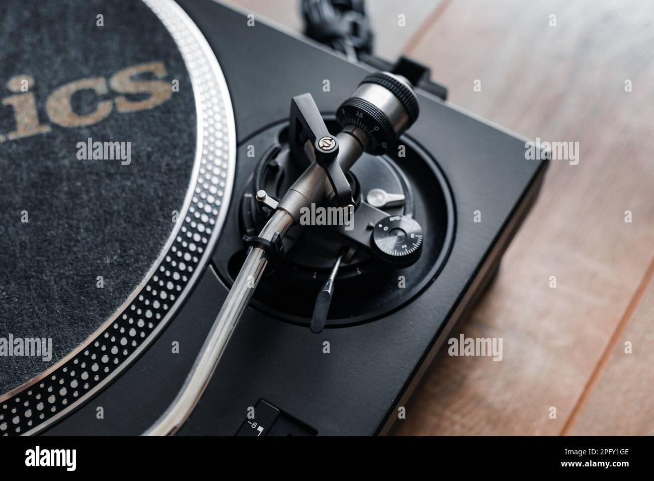 A detailed shot of a vintage turntable, with spinning center, tonearm ...