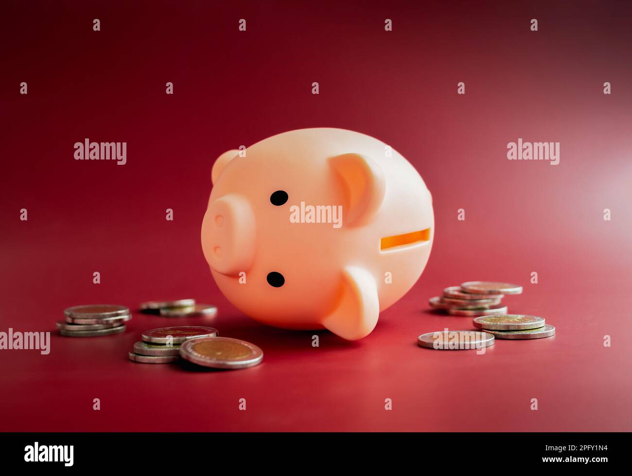 The empty pink piggy bank fall down around with little pile of less ...