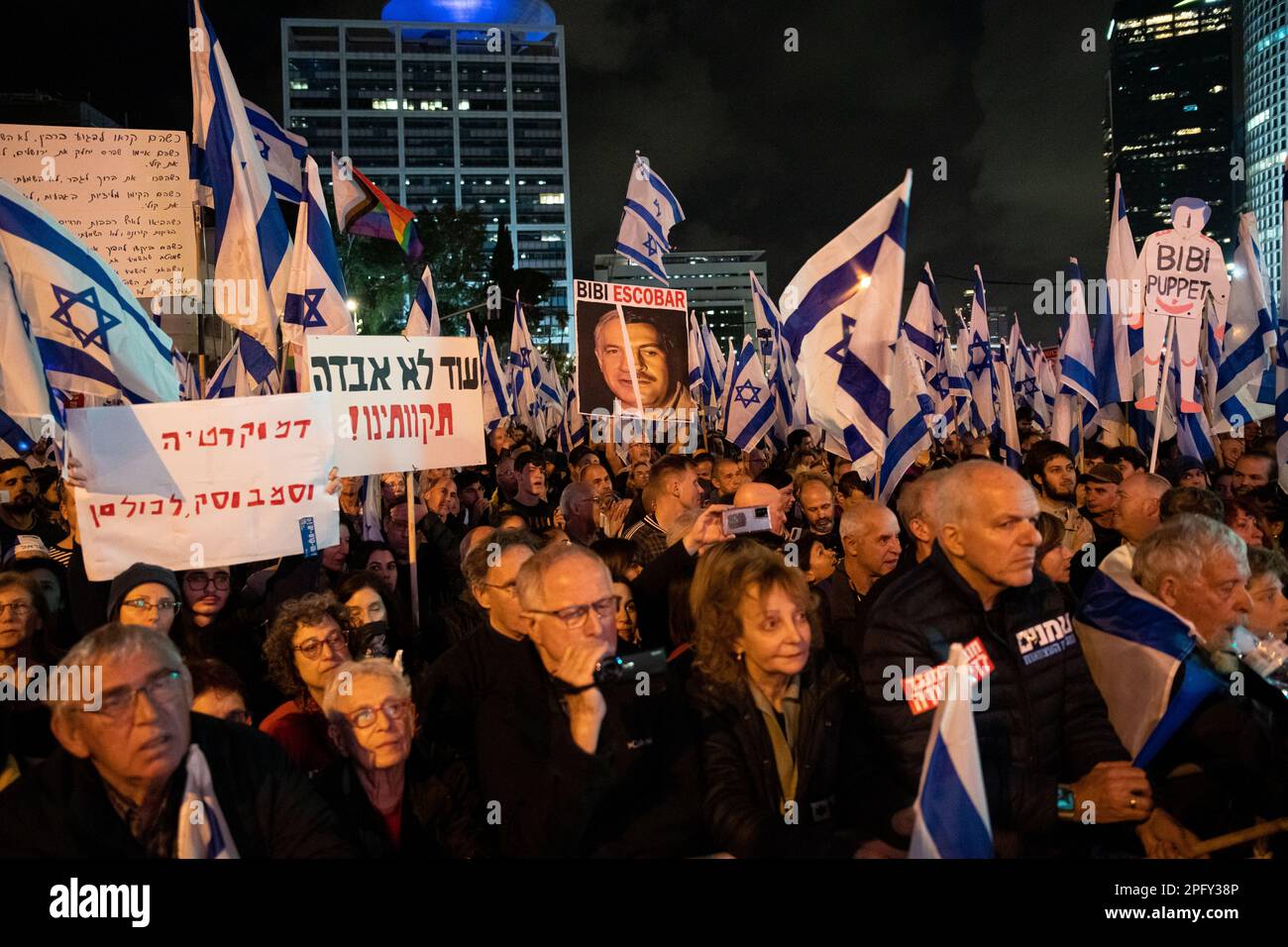 Israel. 18th Mar, 2023. Protestors wave the Israeli flag and signs with ...