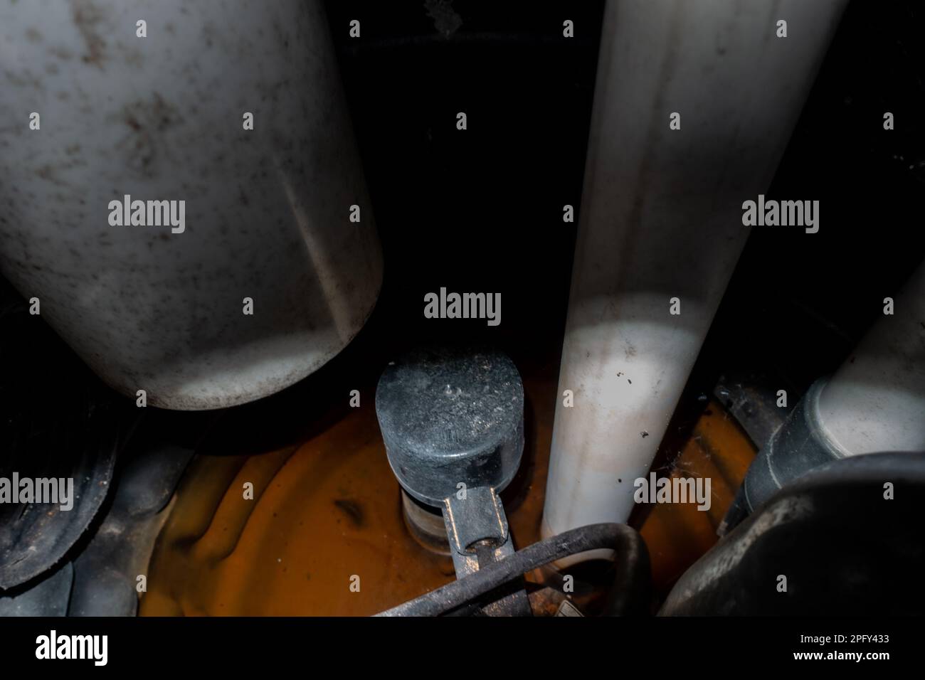 interior view of dark sump pit with pump and float switch visible in ...