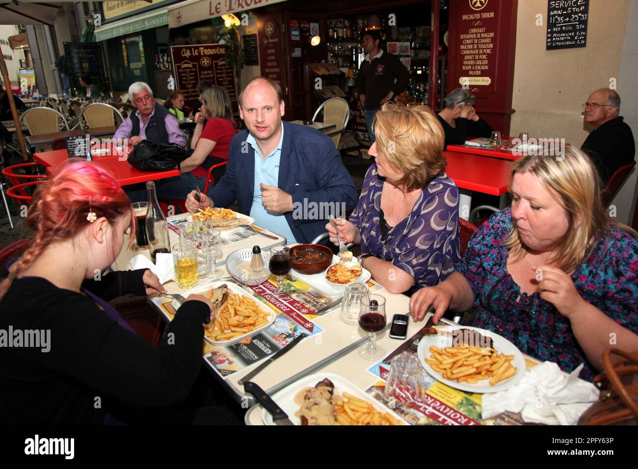A group of men and woman eating out at a restaurant in France Stock ...