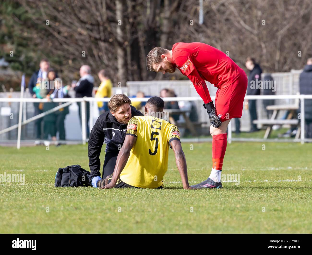Guisely AFC goalkeeper checks on his colleague as the physio attends ...