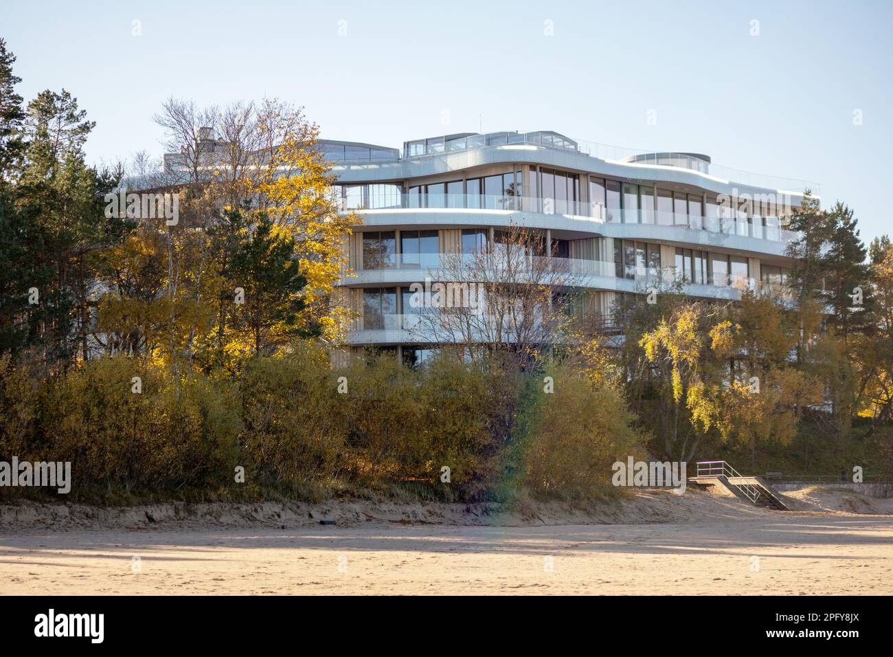 A building with glazed windows and yellow birch trees in front of the ...