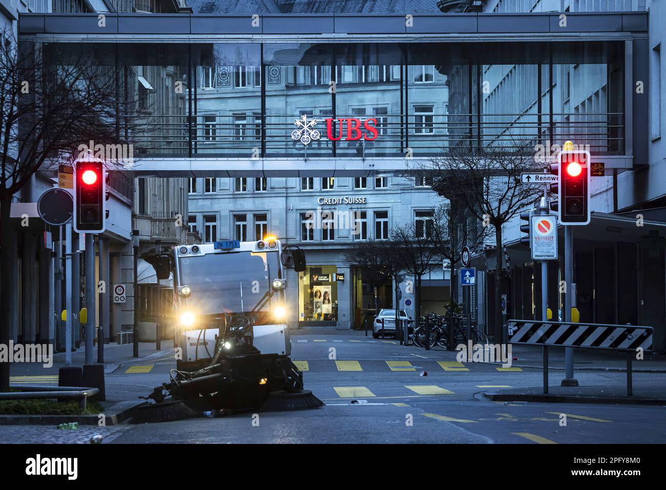A cleaning vehicle collects garbage past the logos of the Swiss banks ...