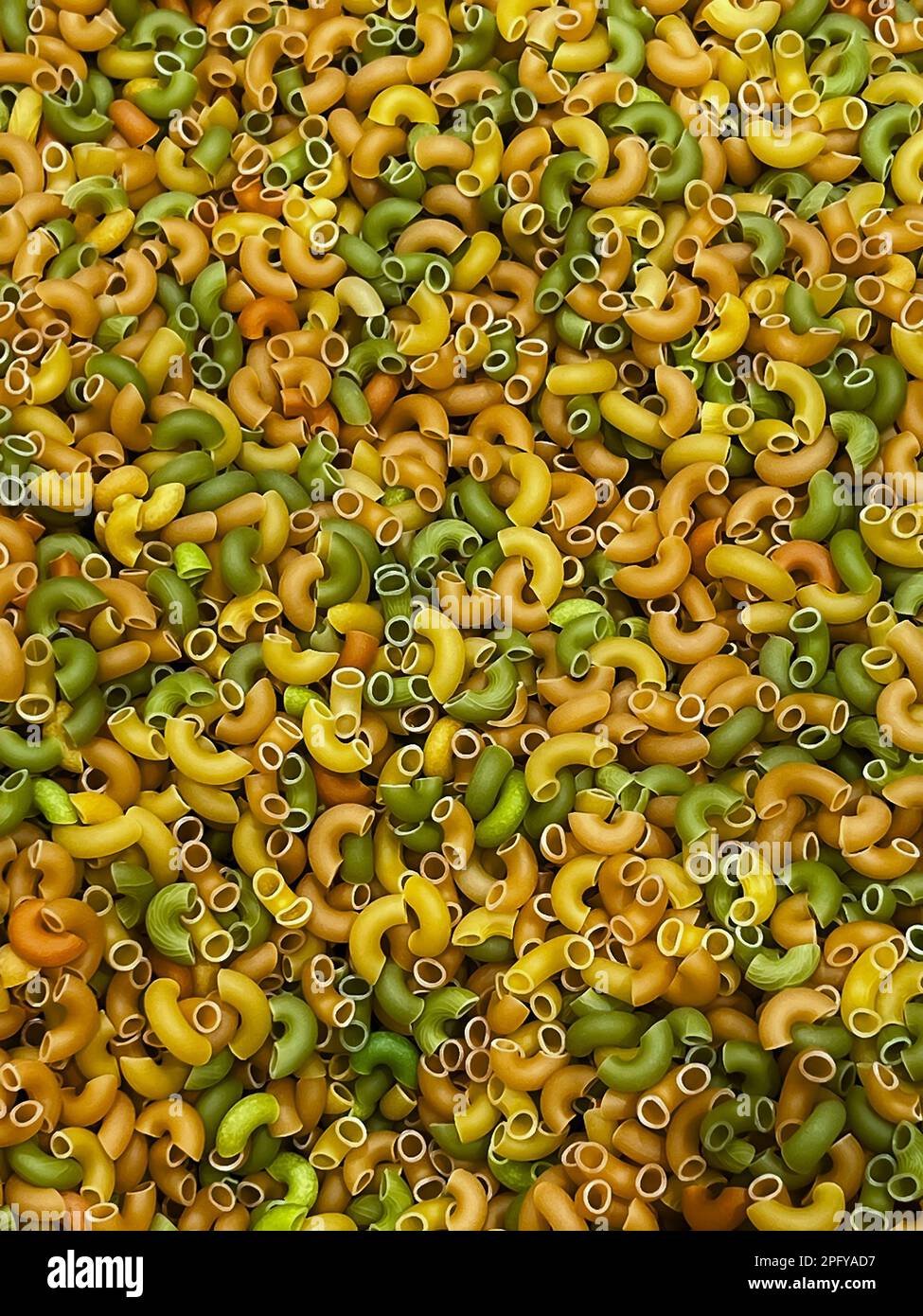 Colored pasta is the background for the design. Colorful macaroni tubes ...