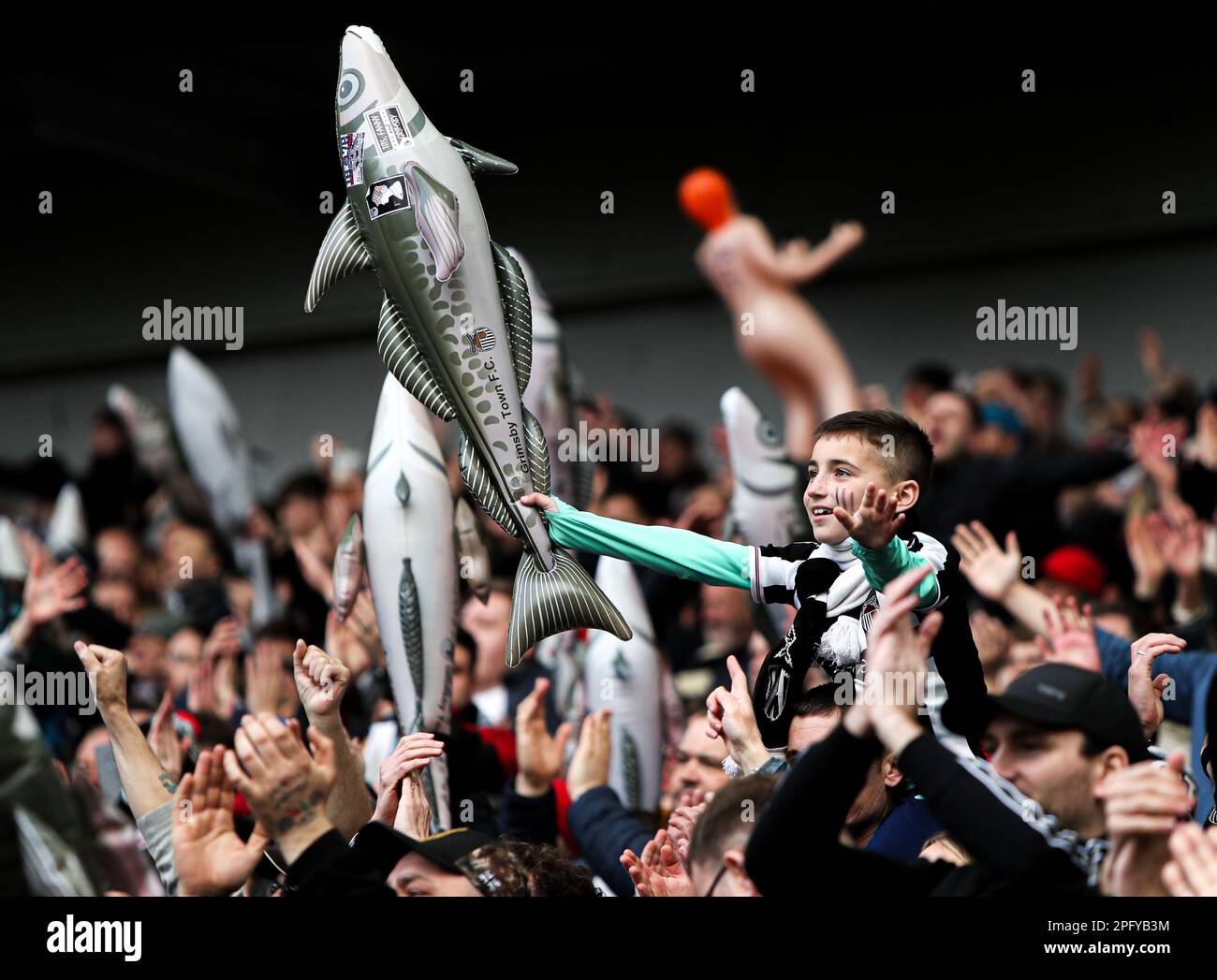 Brighton and Hove, UK. 19th Mar, 2023. A young Grimsby Town fan with an inflatable fish after ...