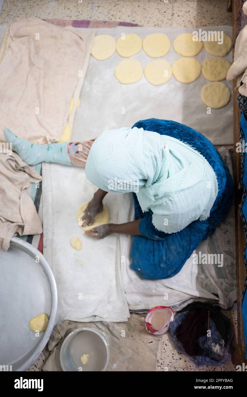 Nefta, Tunisia. 01st Mar, 2023. A woman shapes the dough for the Berber ...