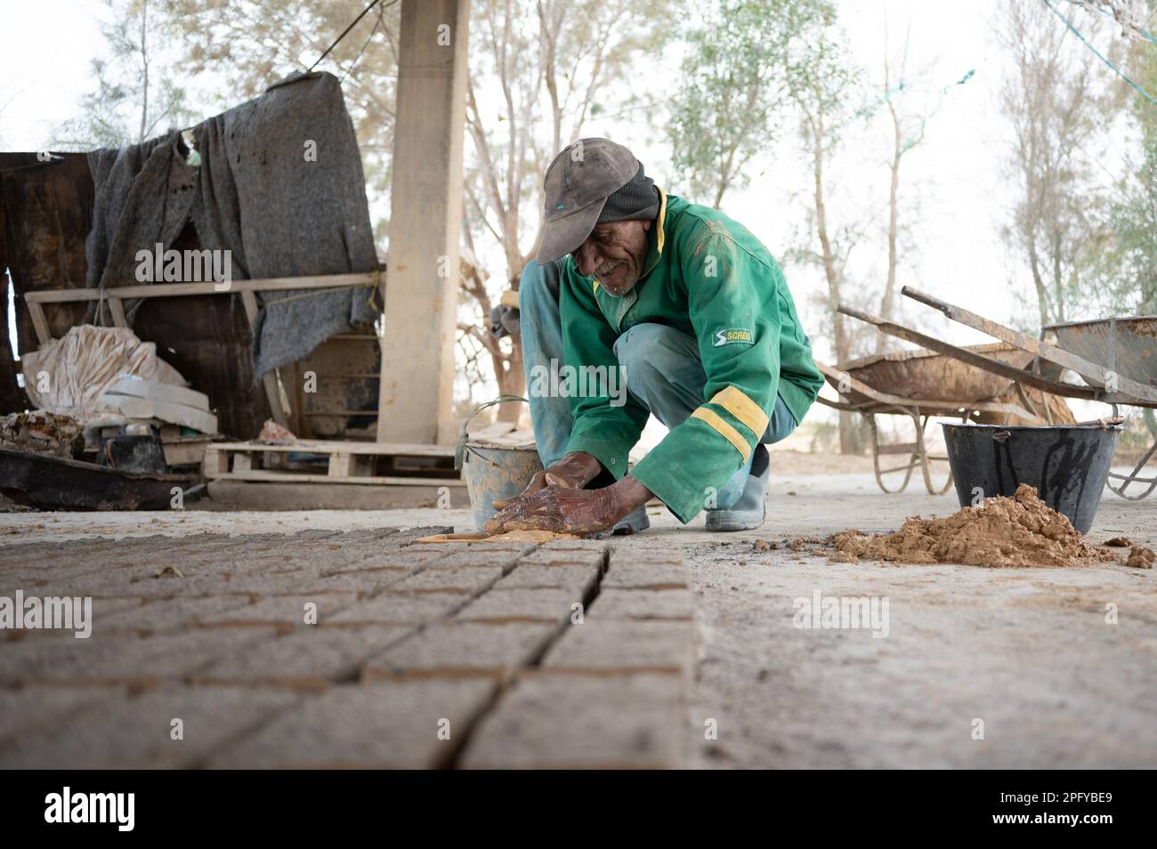 Nefta, Tunisia. 28th Feb, 2023. A brickmaker shapes a clay mixture into ...