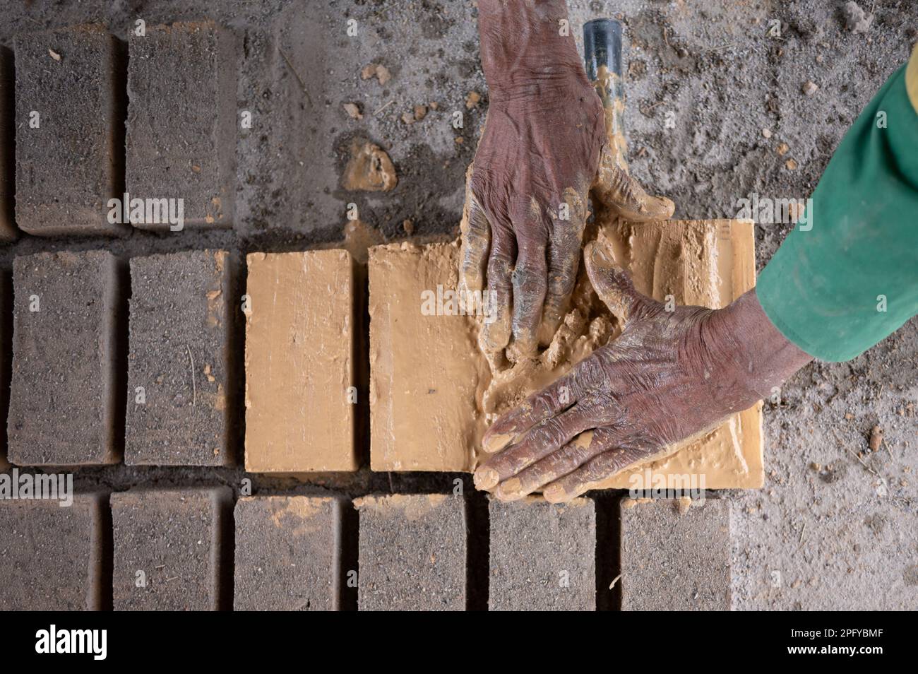 Nefta, Tunisia. 28th Feb, 2023. A brickmaker shapes a clay mixture into adobe bricks using a ...