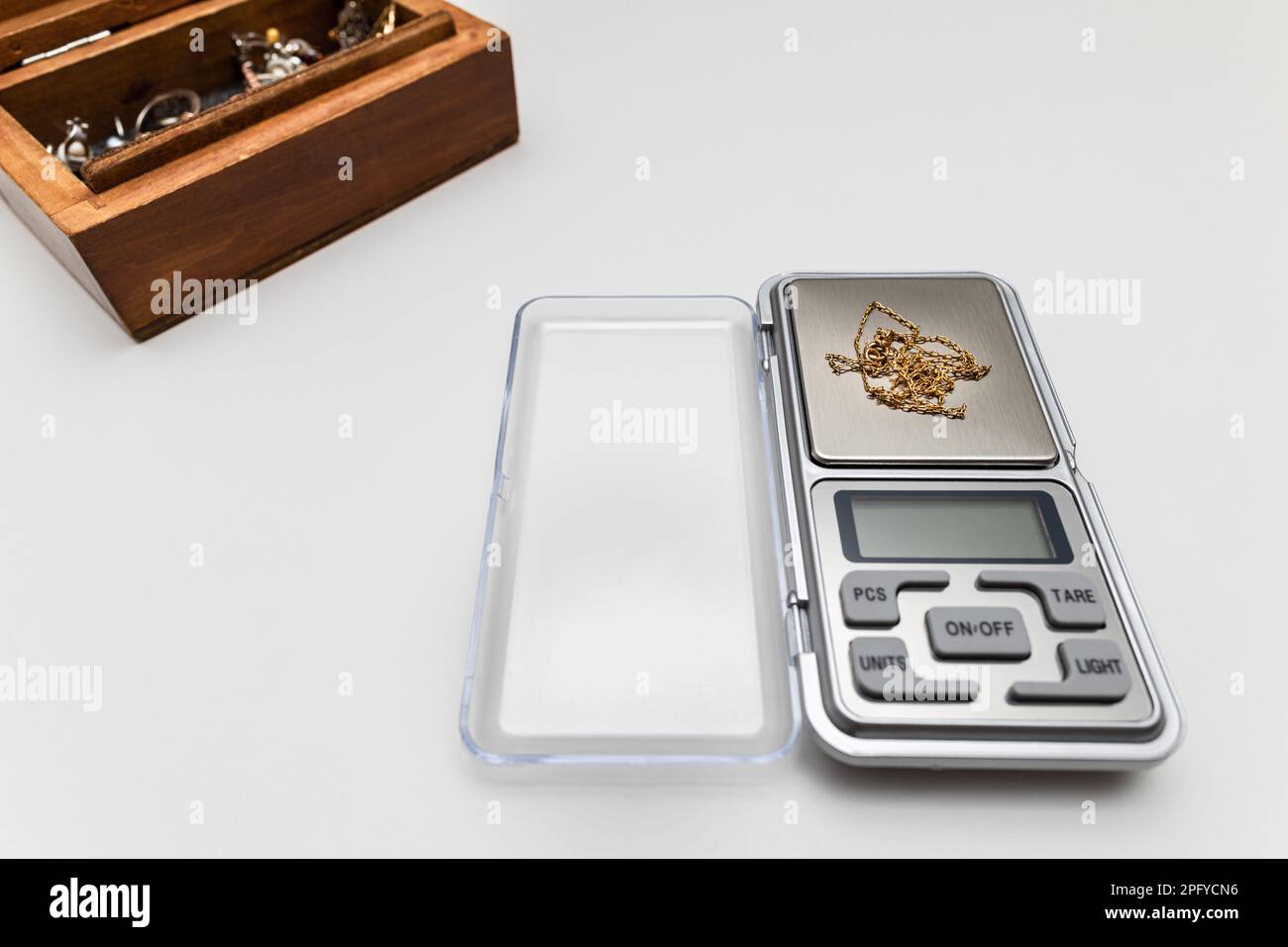 a gold chain lies on a small jewelry scale. jewelry scale Stock Photo ...