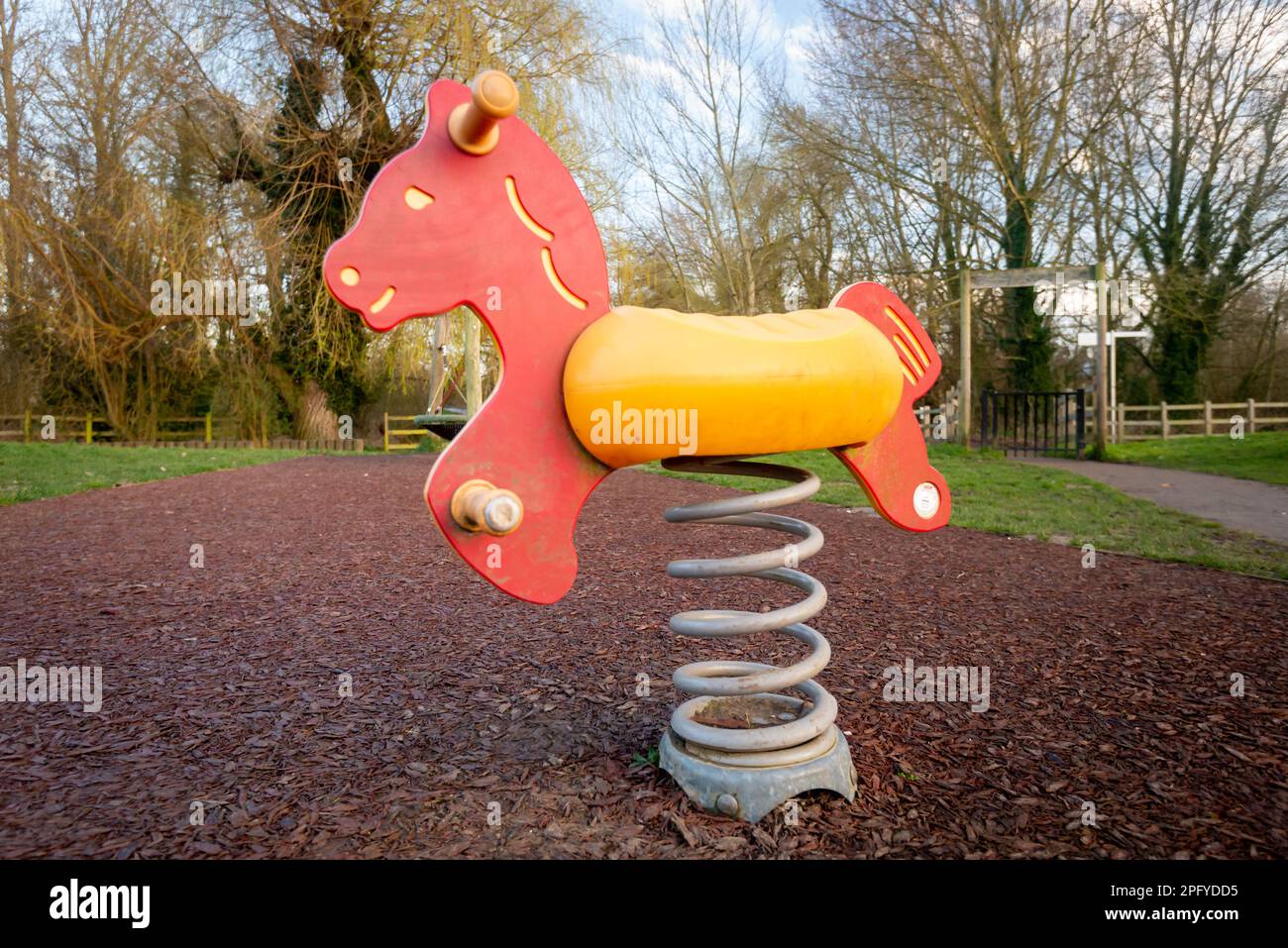Colourful children's rocking horse on springs over wood chip floor in ...