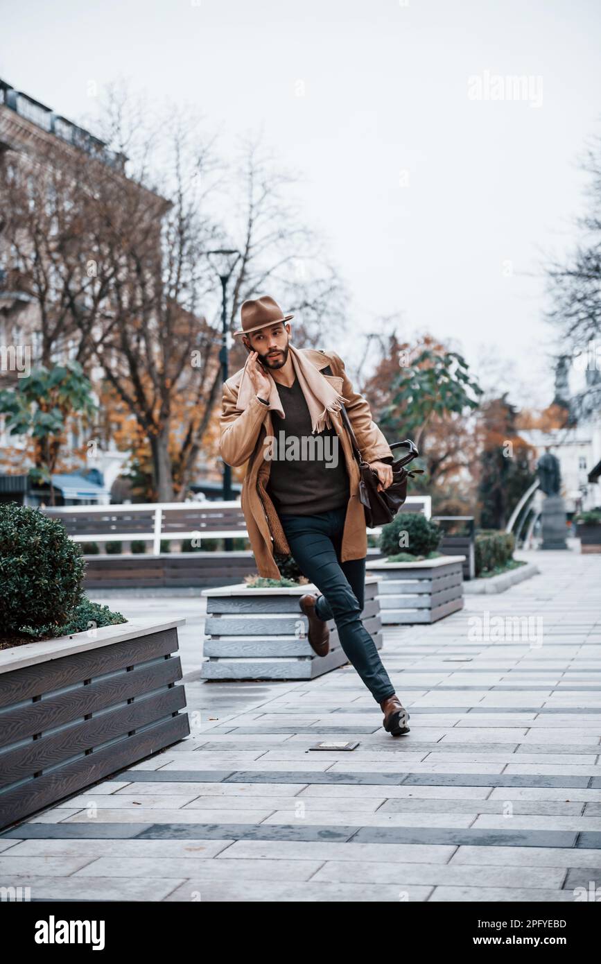 Running, late for meeting. Young male model in fashionable clothes is ...