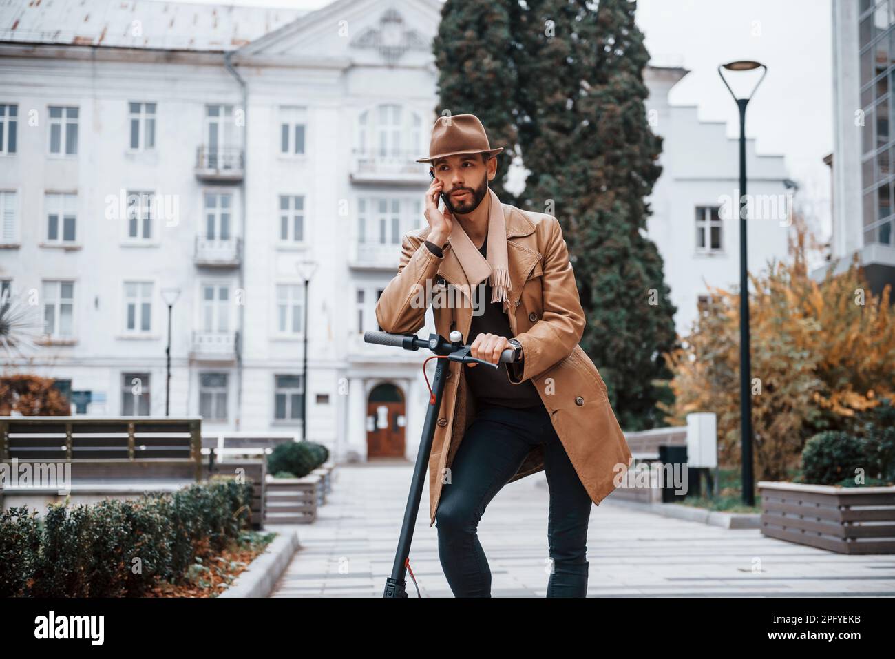 On the electric scooter. Young male model in fashionable clothes is ...