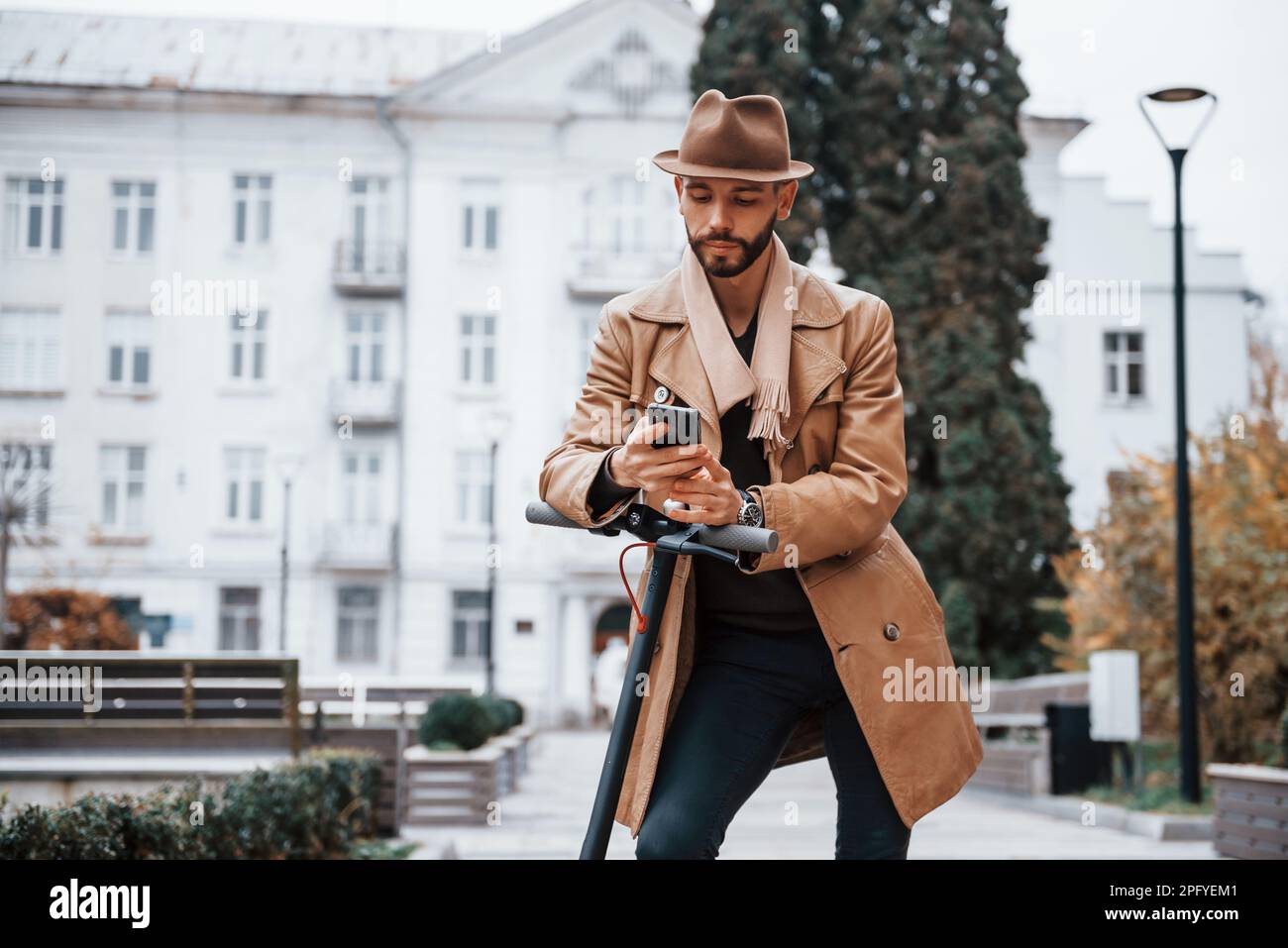On the electric scooter. Young male model in fashionable clothes is ...