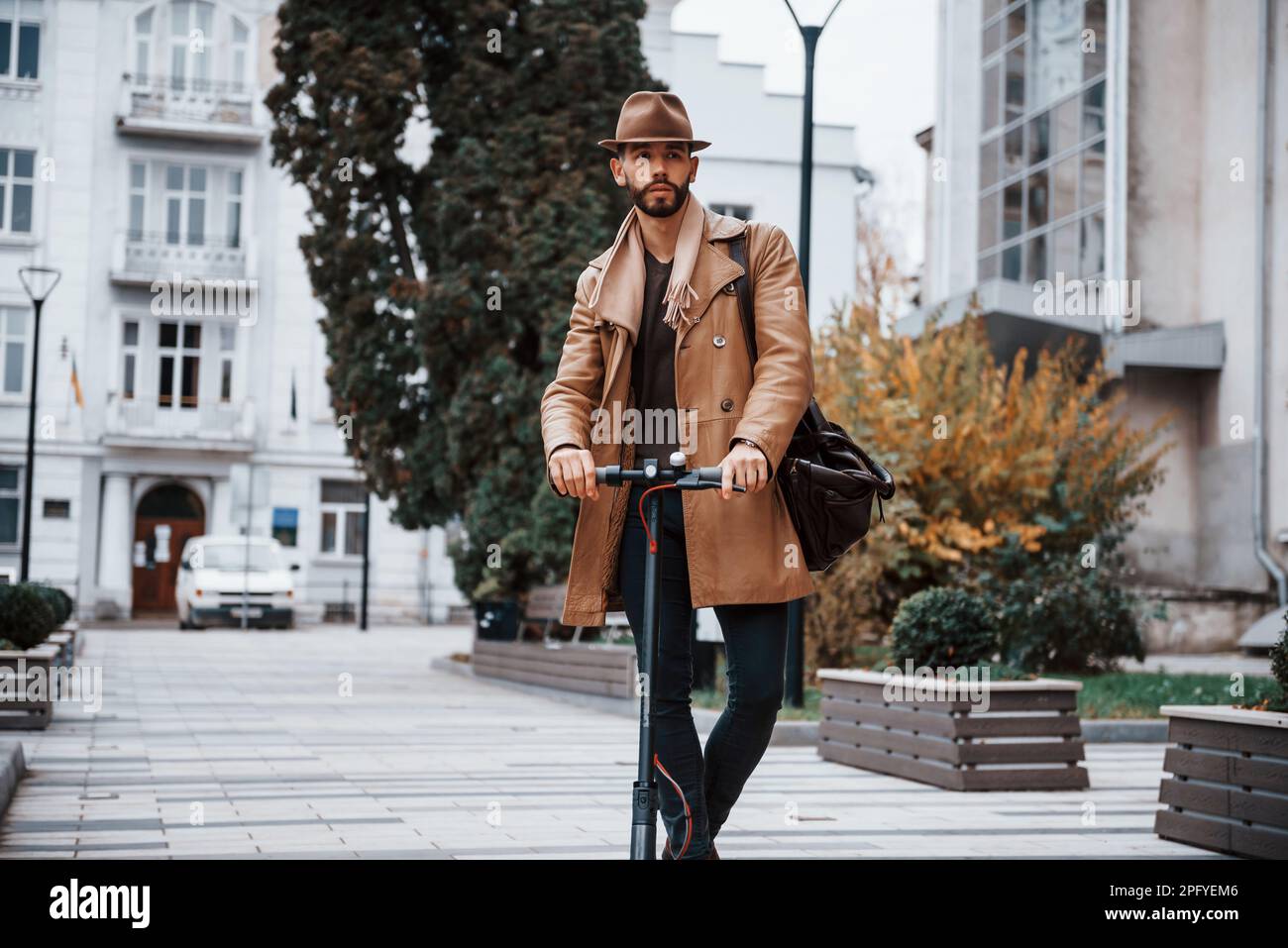 On the electric scooter. Young male model in fashionable clothes is ...