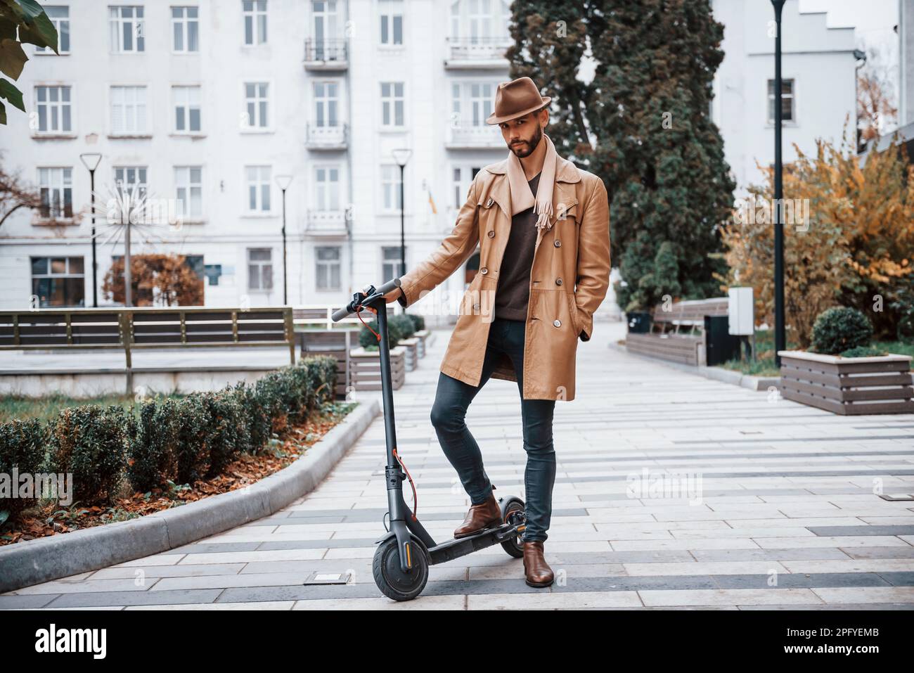 On the electric scooter. Young male model in fashionable clothes is ...