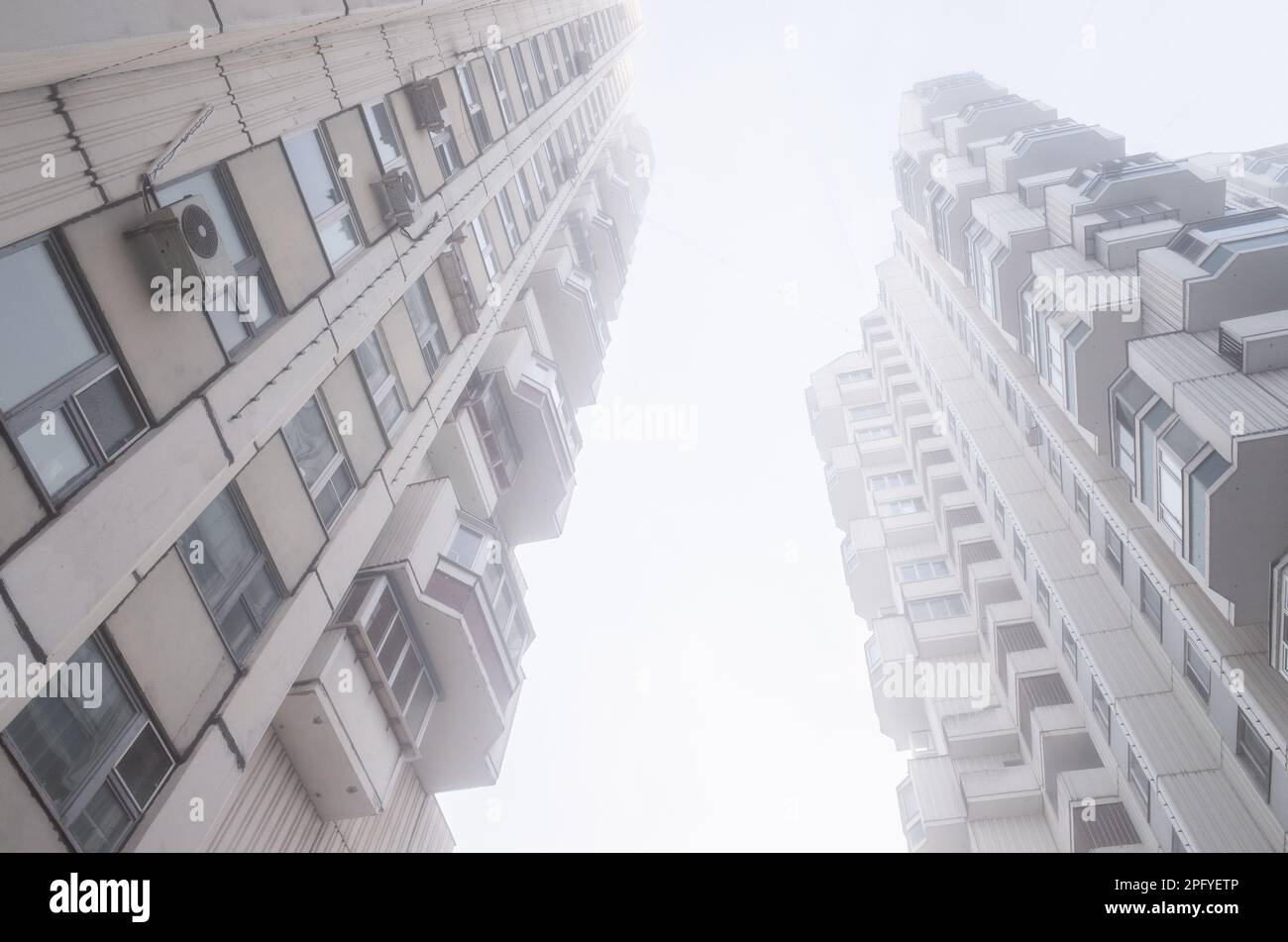 Tall residential buildings in the form of a tower, immersed in a misty ...