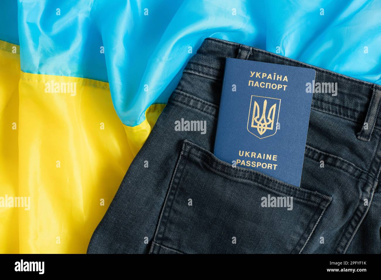 A foreign biometric Ukrainian passport lies in a jeans pocket against ...
