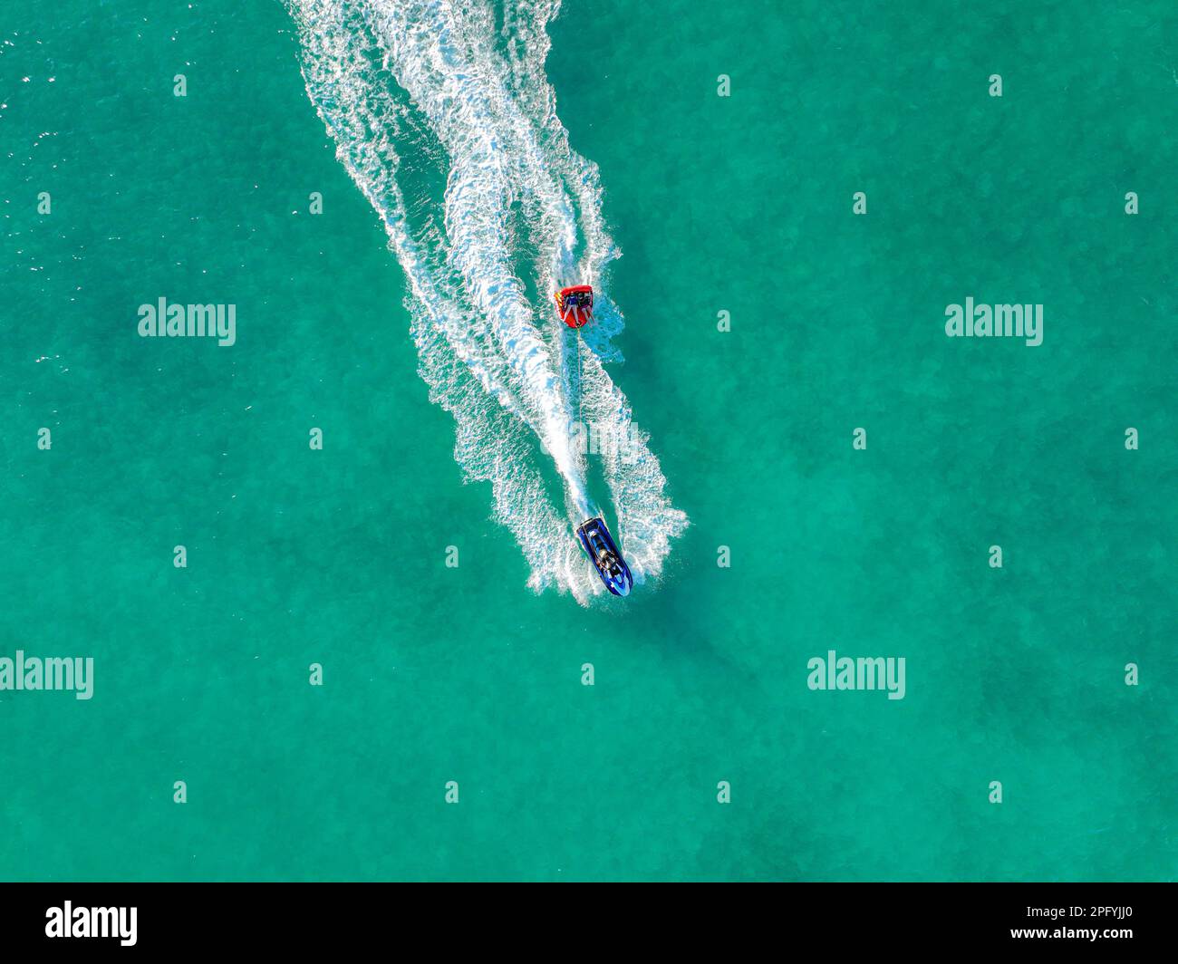 An aerial top view of a speed boat navigating the open ocean performing ...