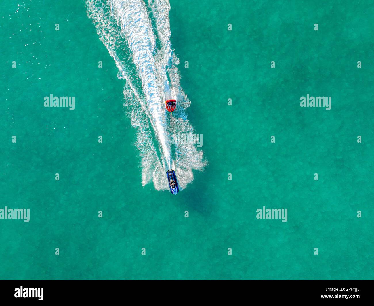 An aerial top view of a speed boat navigating the open ocean performing ...