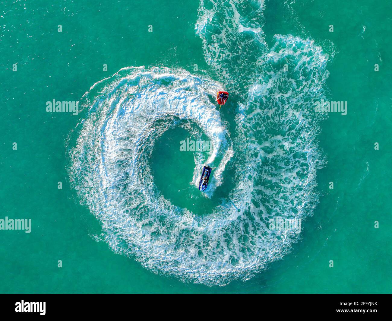 An aerial top view of a speed boat navigating the open ocean performing ...
