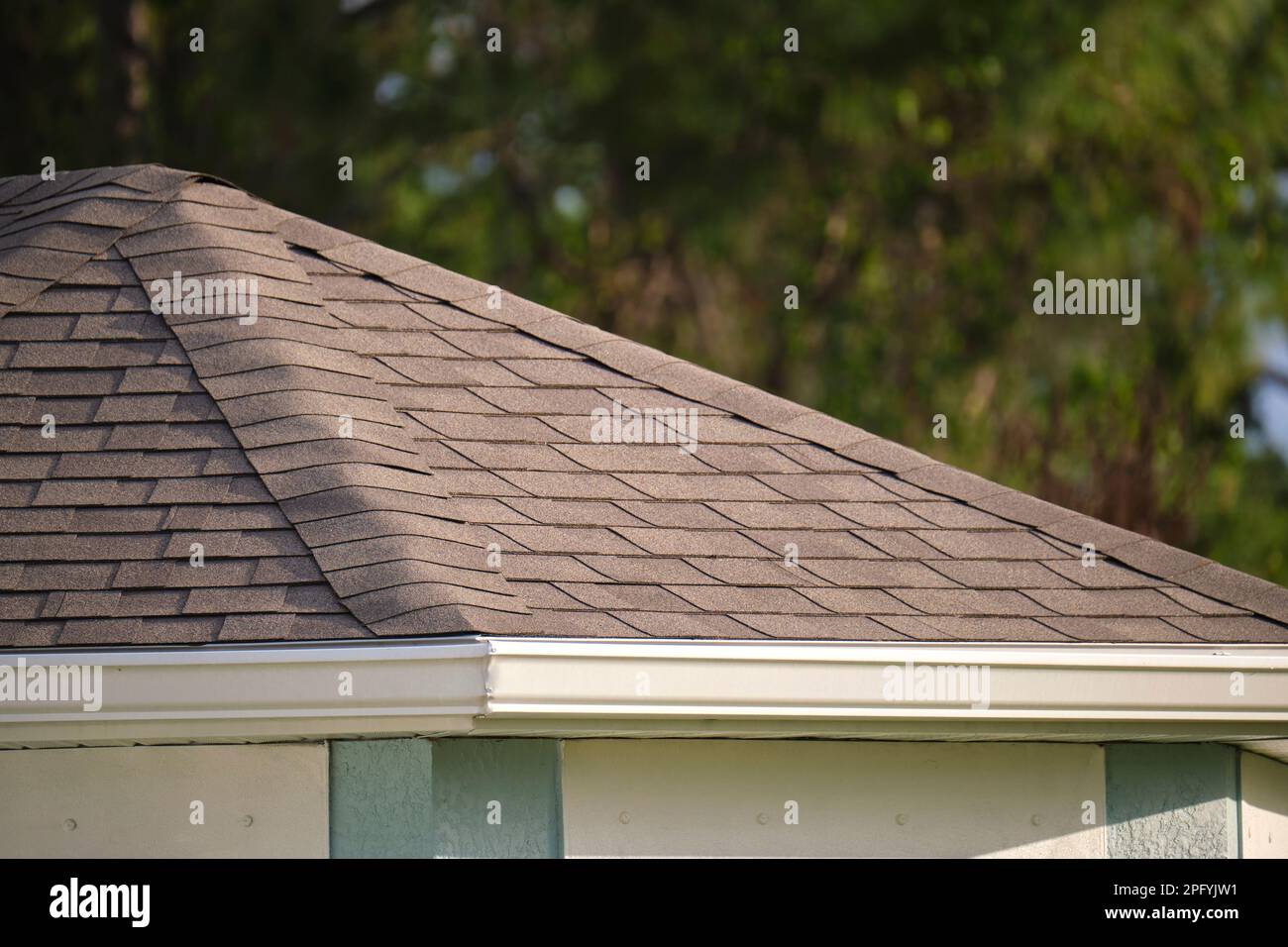 Closeup of house roof top covered with asphalt or bitumen shingles ...