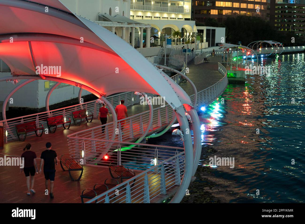 People enjoying time walking on pedestrian riverwalk trail alongside ...