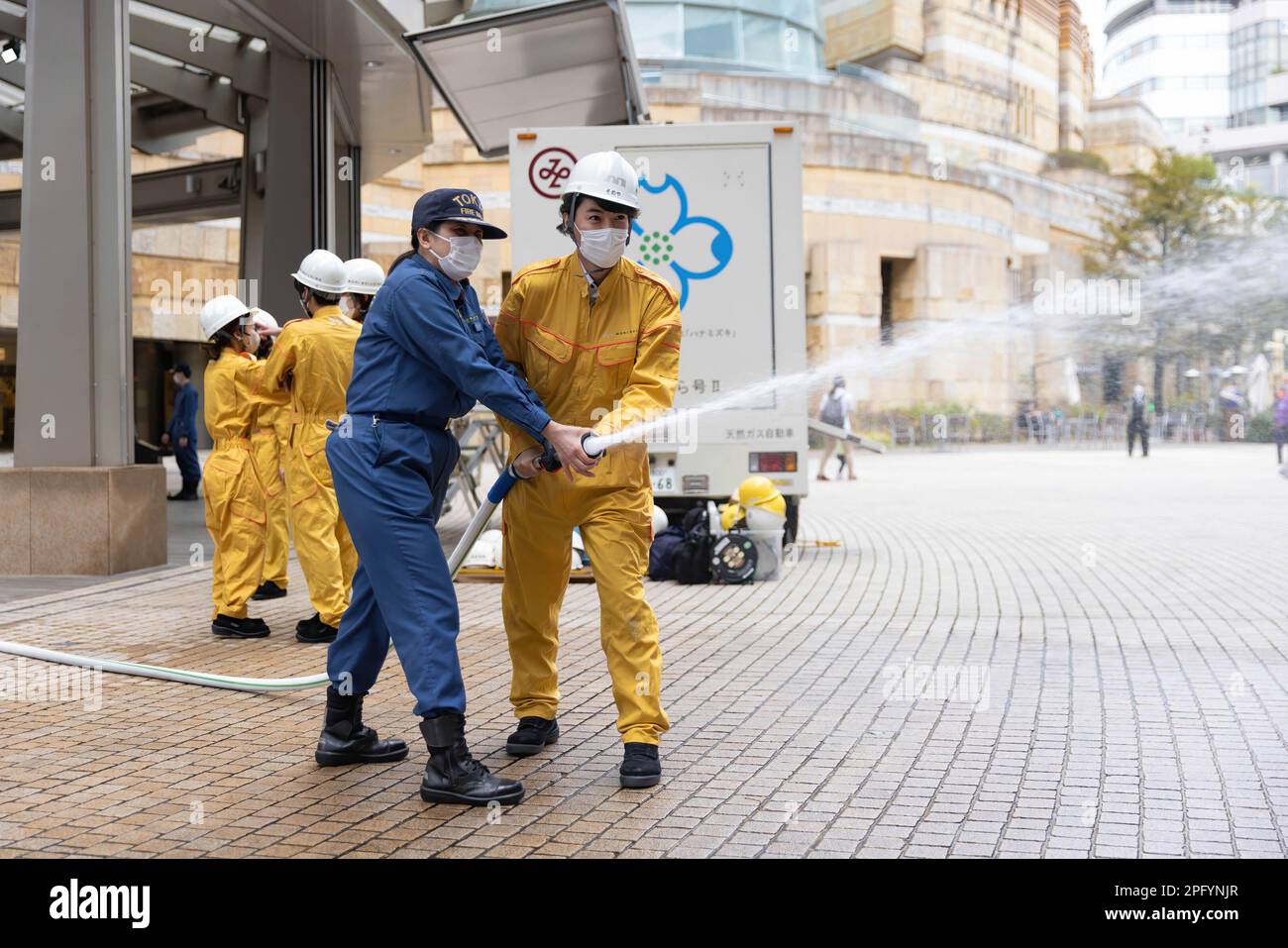 Tokyo fire brigade shows a participant how to stop fire outbreak during ...