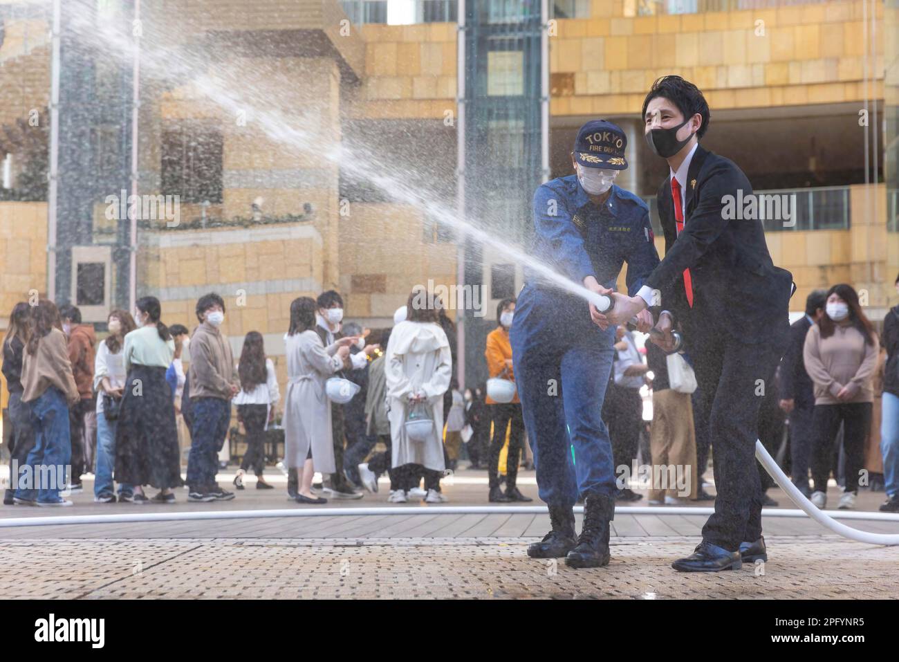 Tokyo fire brigade shows a participant how to stop fire outbreak during ...