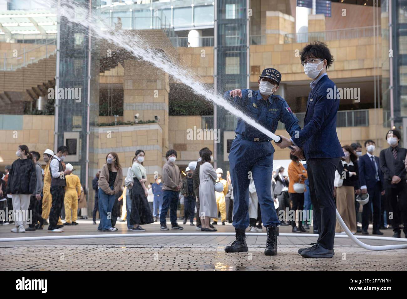 Tokyo fire brigade shows a participant how to stop fire outbreak during ...