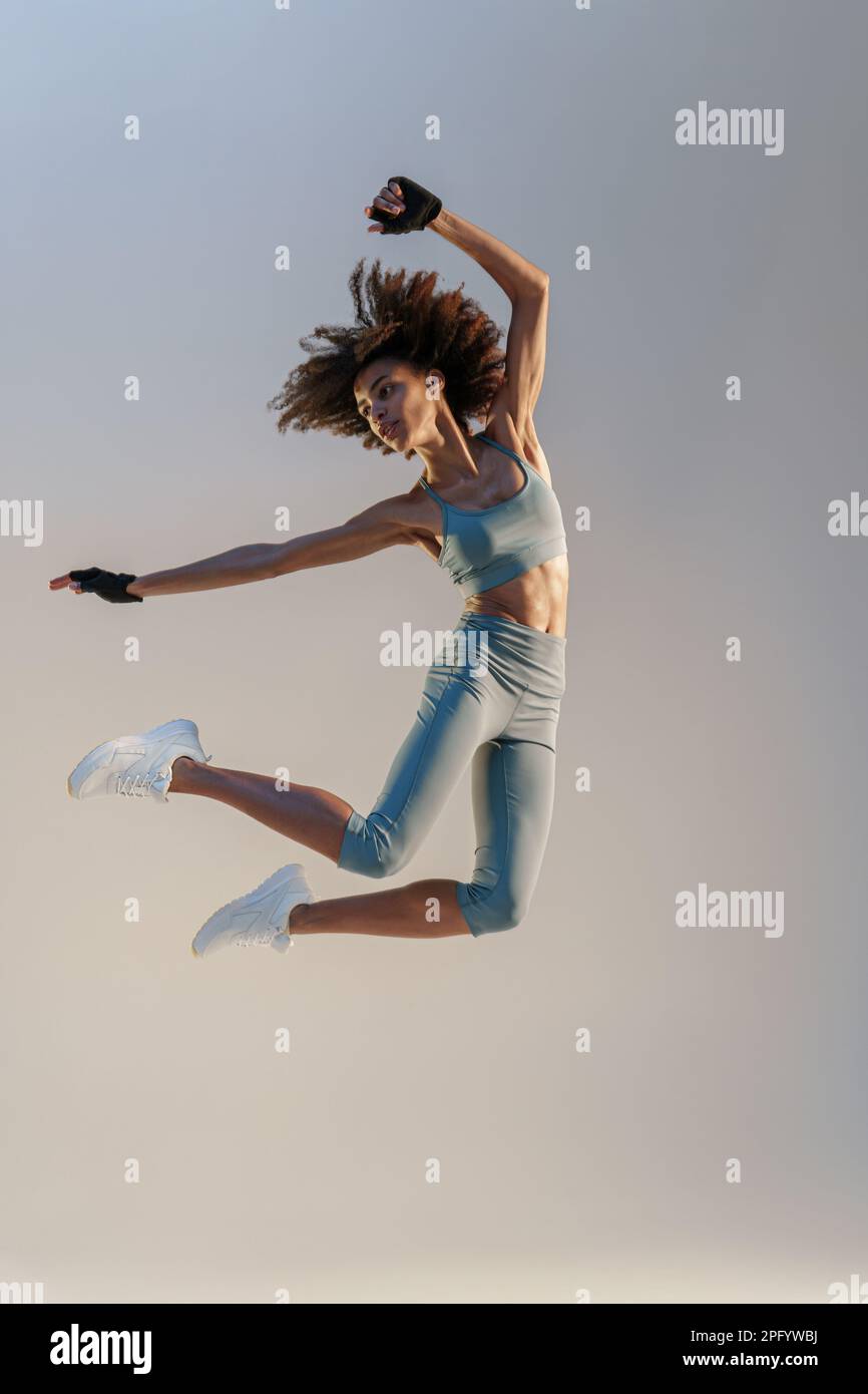 Active sporty woman in sportswear jumping on studio background. Sport ...