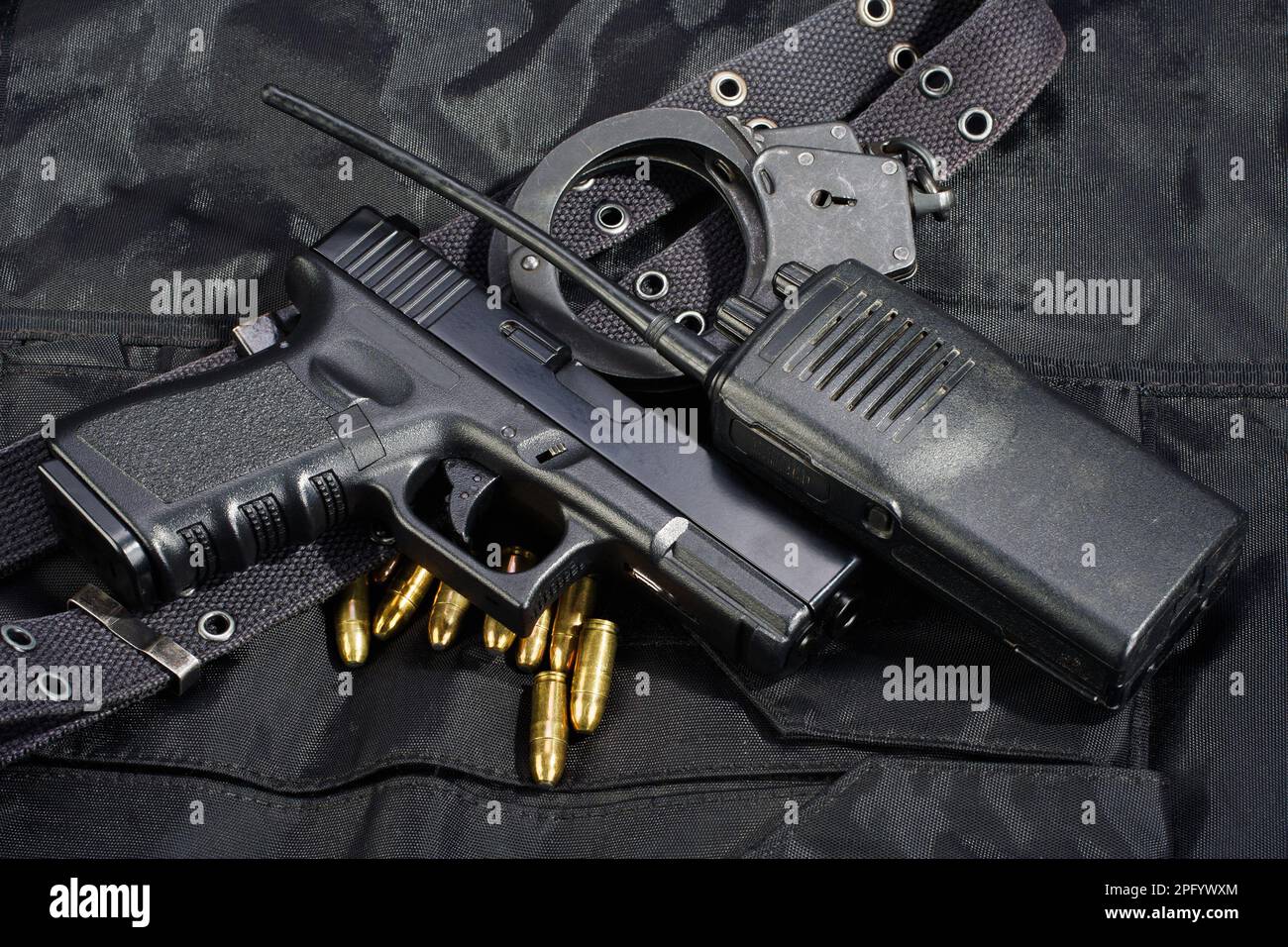 Police weapon and equipment and handcuffs on black uniform background ...