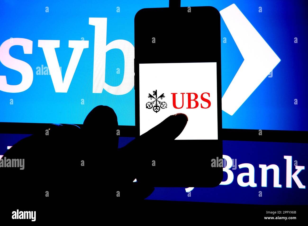 In this photo illustration, an UBS logo is displayed on a smartphone with a Silicon valley Bank ...