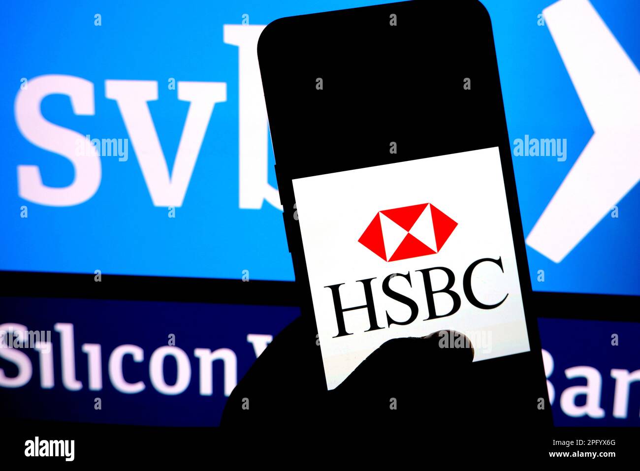 In this photo illustration, a HSBC logo is displayed on a smartphone with a Silicon valley Bank ...