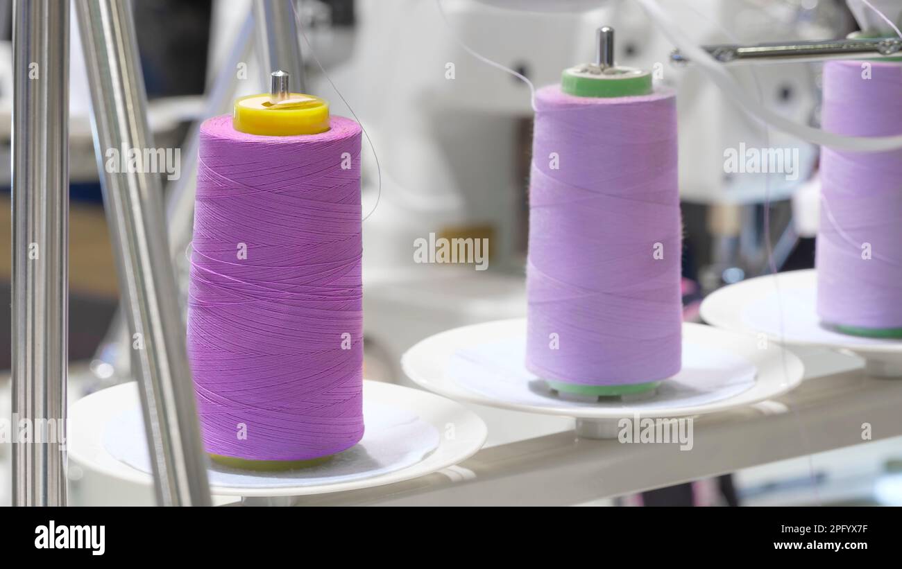 Reels of textile yarn blue thread at industrial weaving manufacturing ...