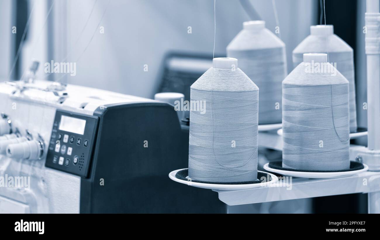 Reels of textile yarn blue thread at industrial weaving manufacturing ...